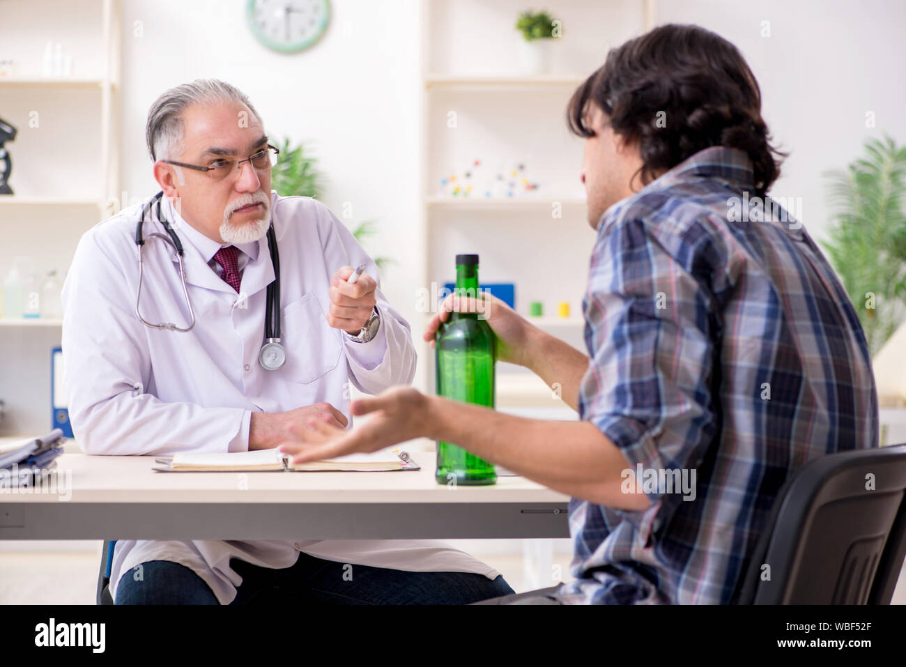 The young male alcoholic visiting old doctor Stock Photo - Alamy