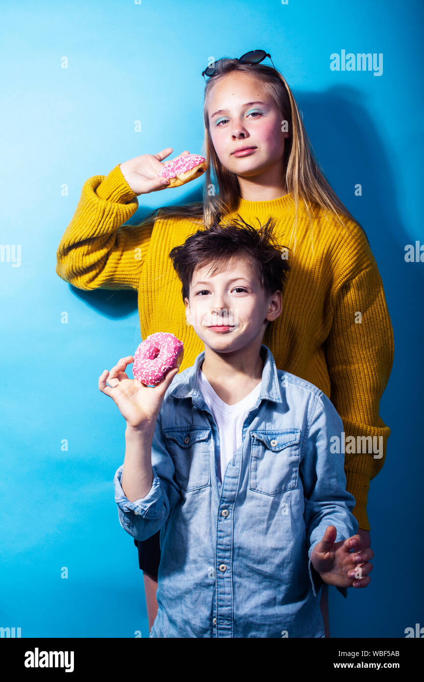 happy family brother and sister eating donuts on blue background ...