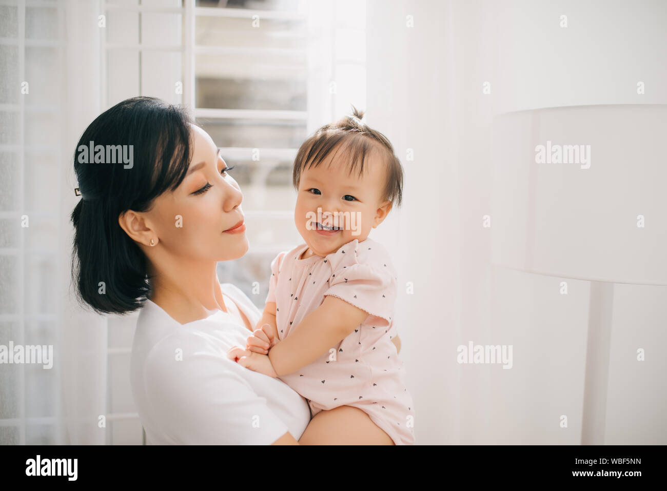 Portrait of happy vietnamese mother hugging with her cute little daughter at home Stock Photo ...
