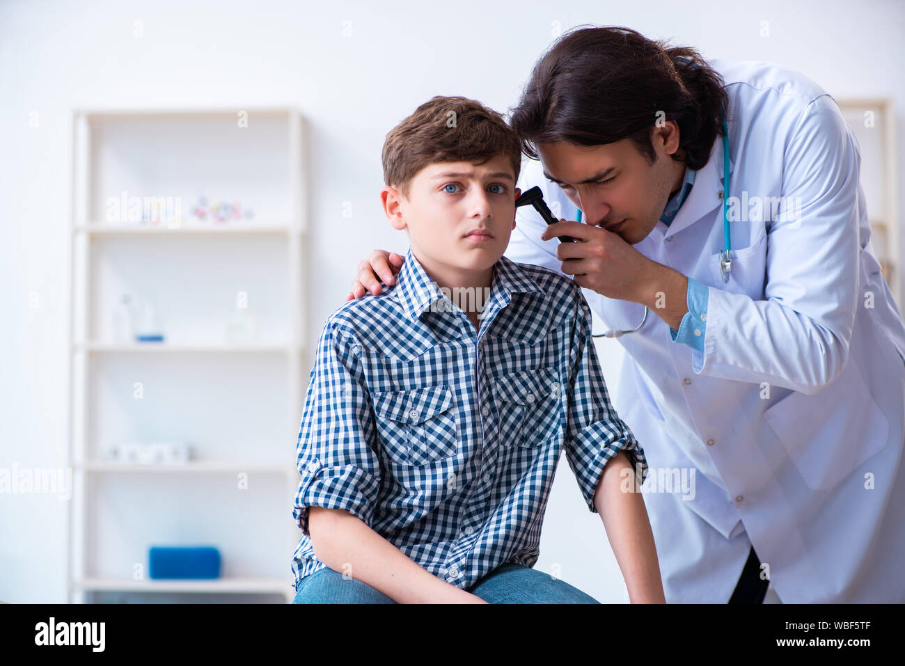 The male otolaryngologist examining boy's ear Stock Photo - Alamy