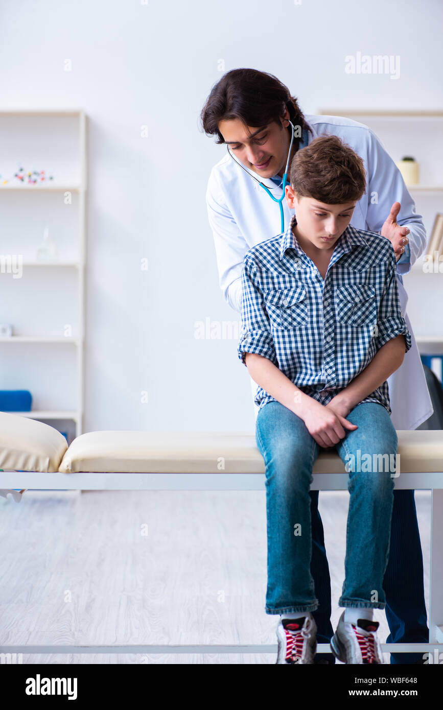 The male doctor examining boy by stethoscope Stock Photo - Alamy