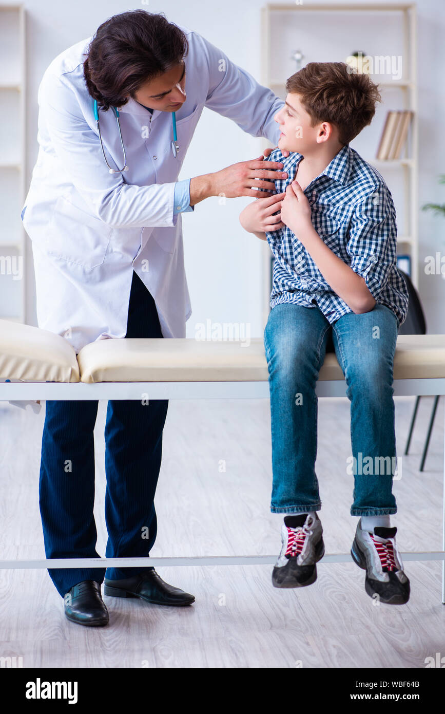 The young doctor examining schoolboy for regular check-up Stock Photo ...