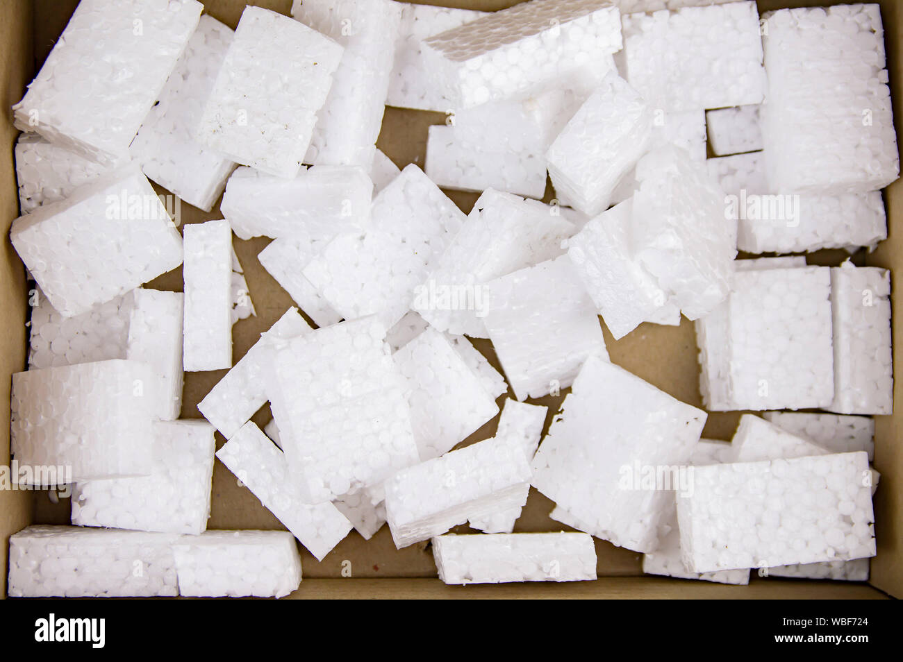 White foam in a carton box - packaging for fragile items. Background ...