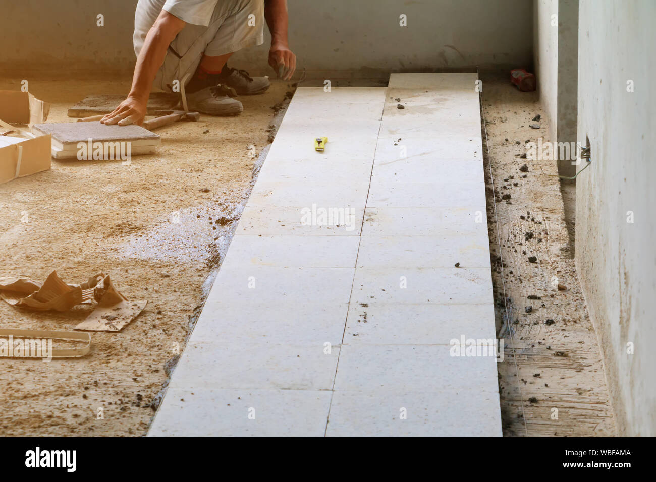 worker installing block Polished stone floor interior the building ...