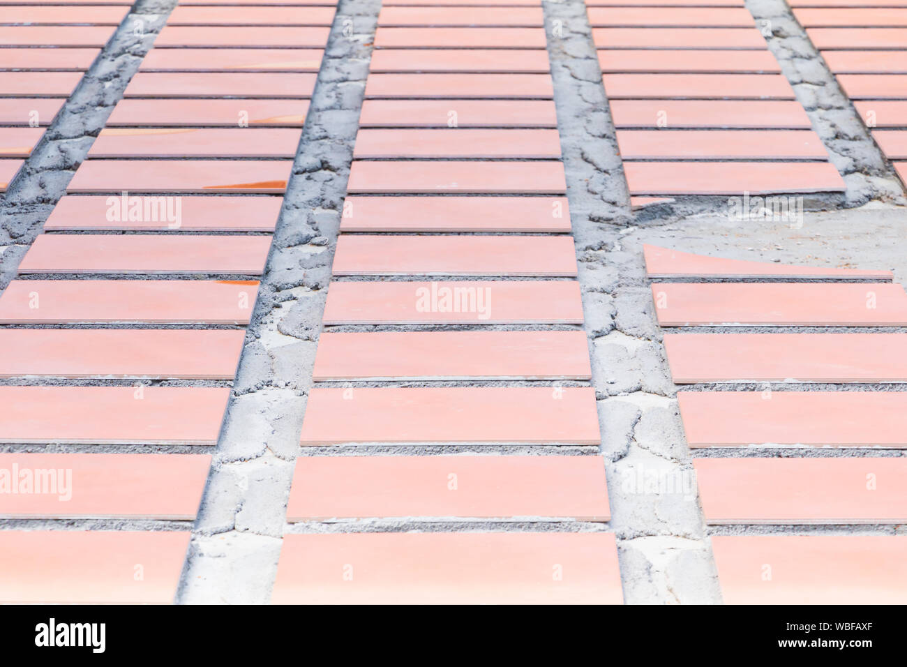 row tile ceramic orange on floor install with cement in work ...