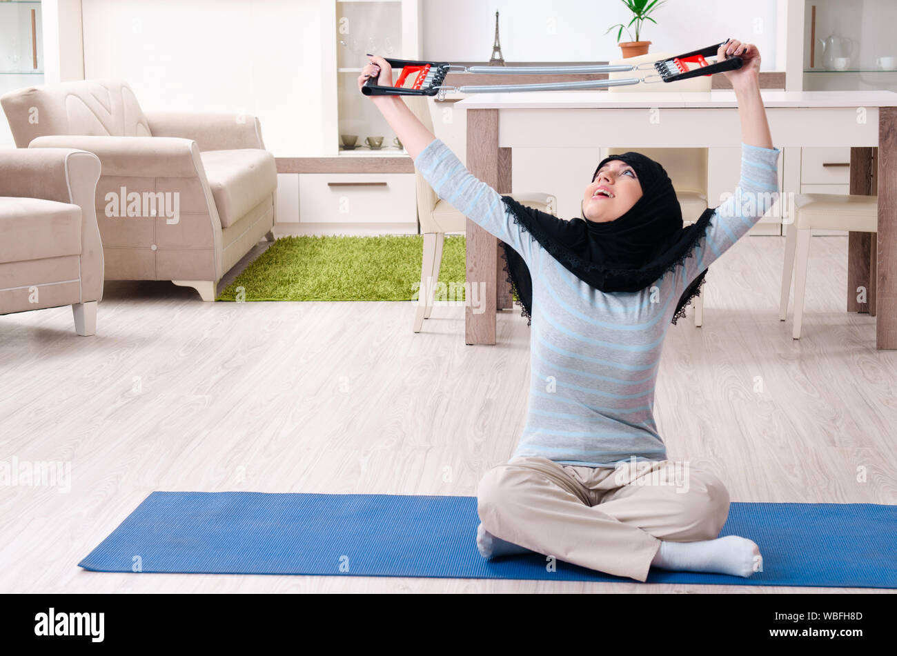 The young woman in hijab doing exercises at home Stock Photo - Alamy