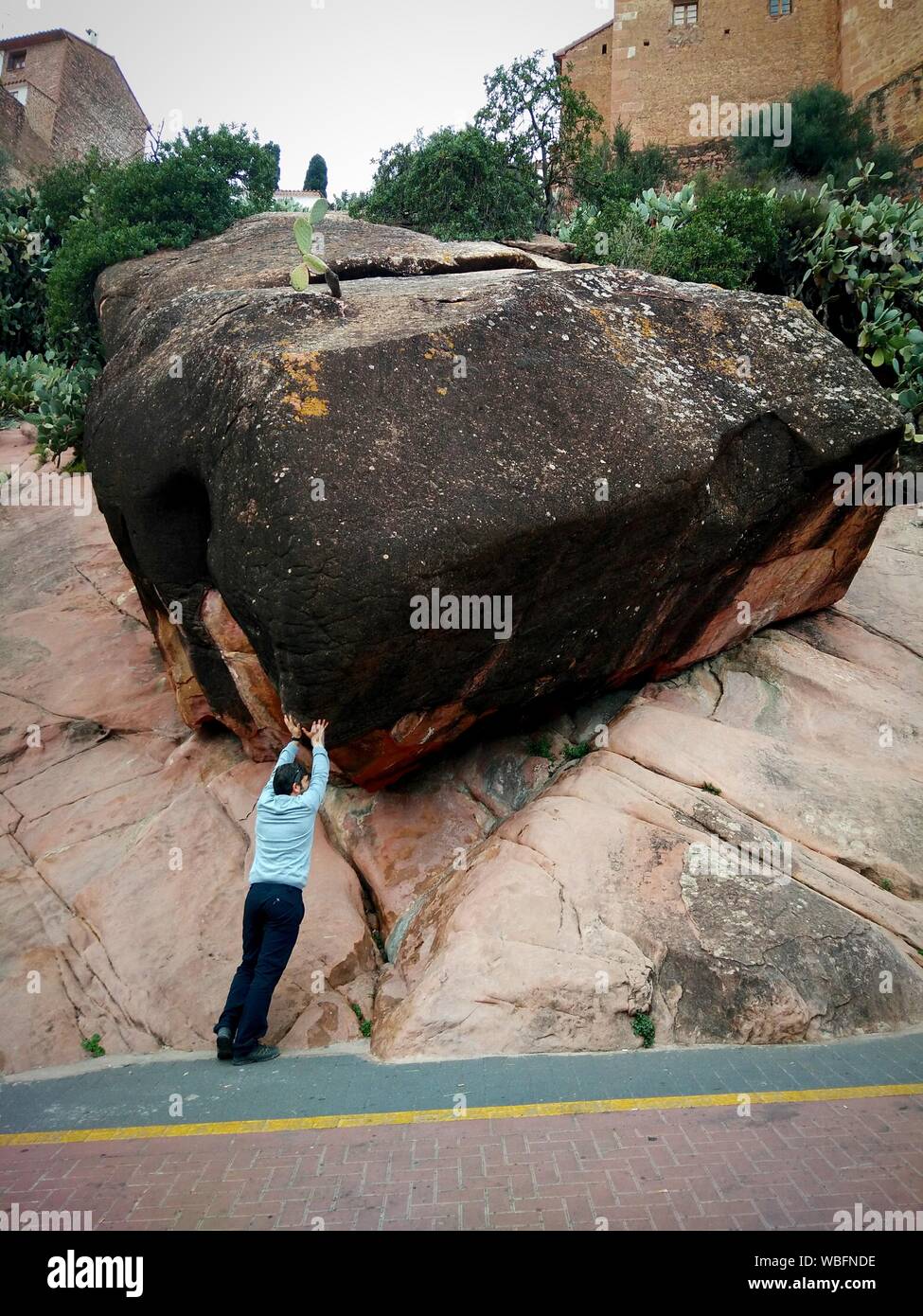Full Length Of Man Touching Rock Stock Photo - Alamy