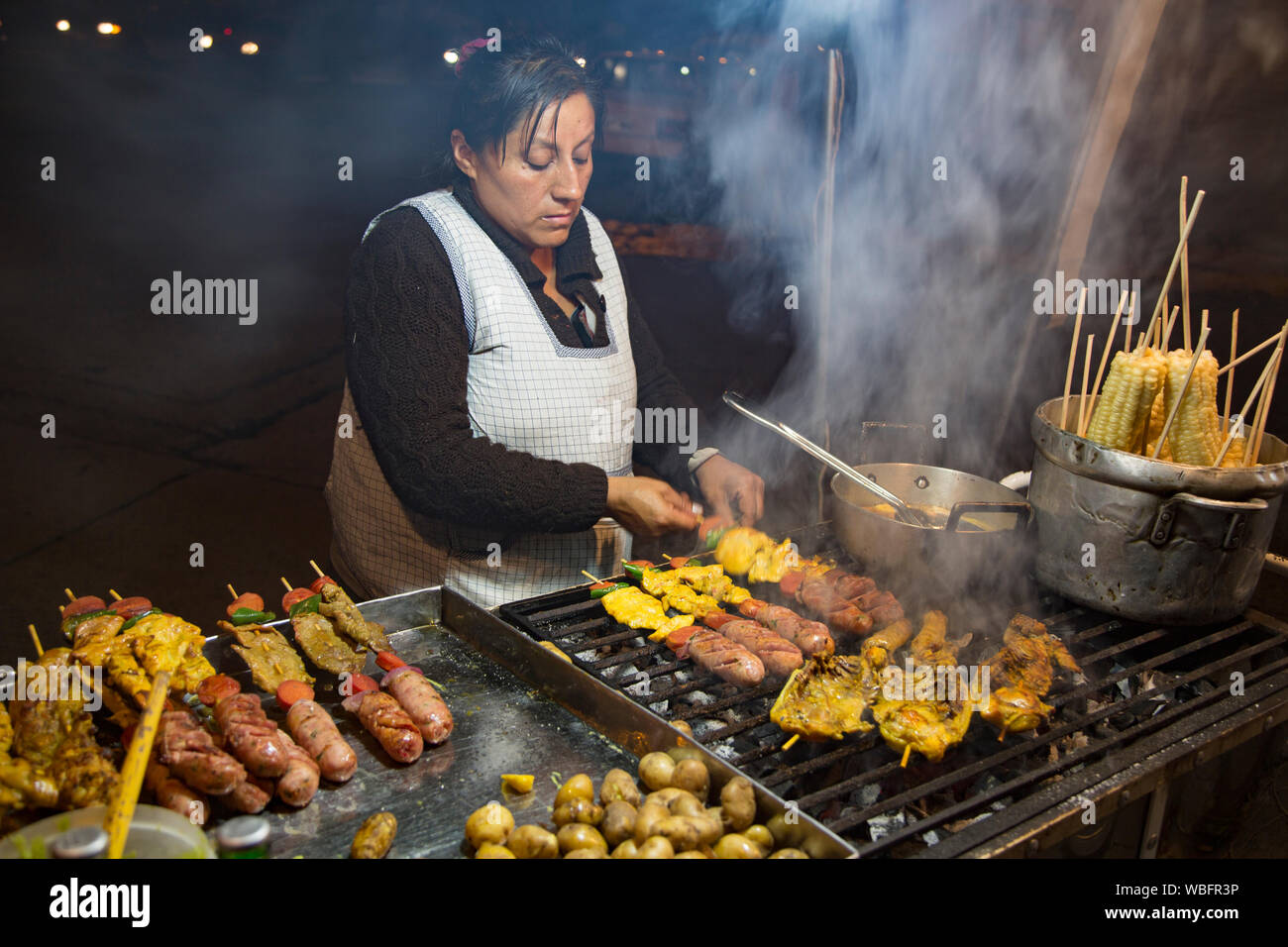 Cuenca, Ecuador - Street food vendor prepares shish kabob of sausage ...