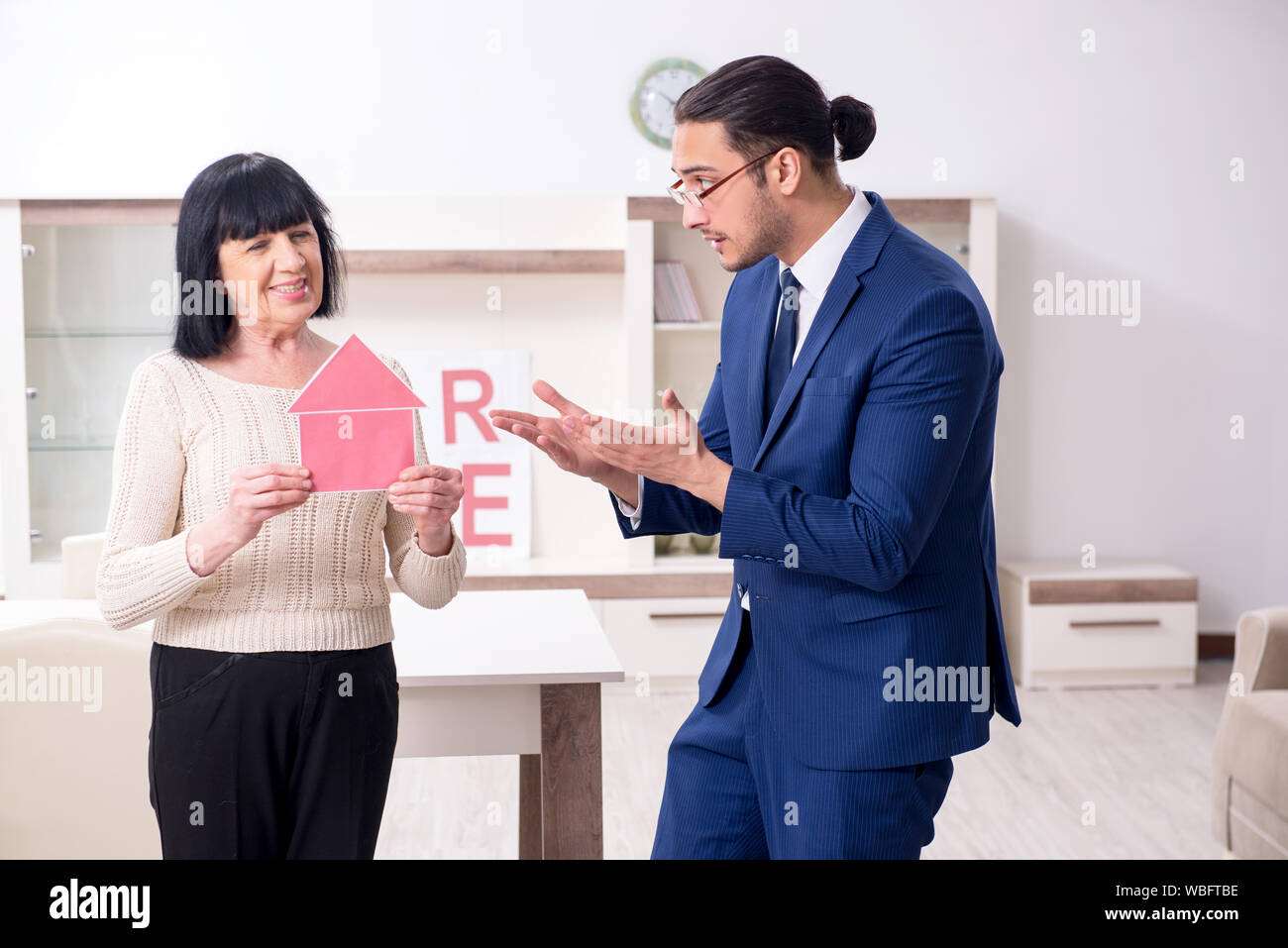 The male real estate agent and female client in the apartment Stock ...
