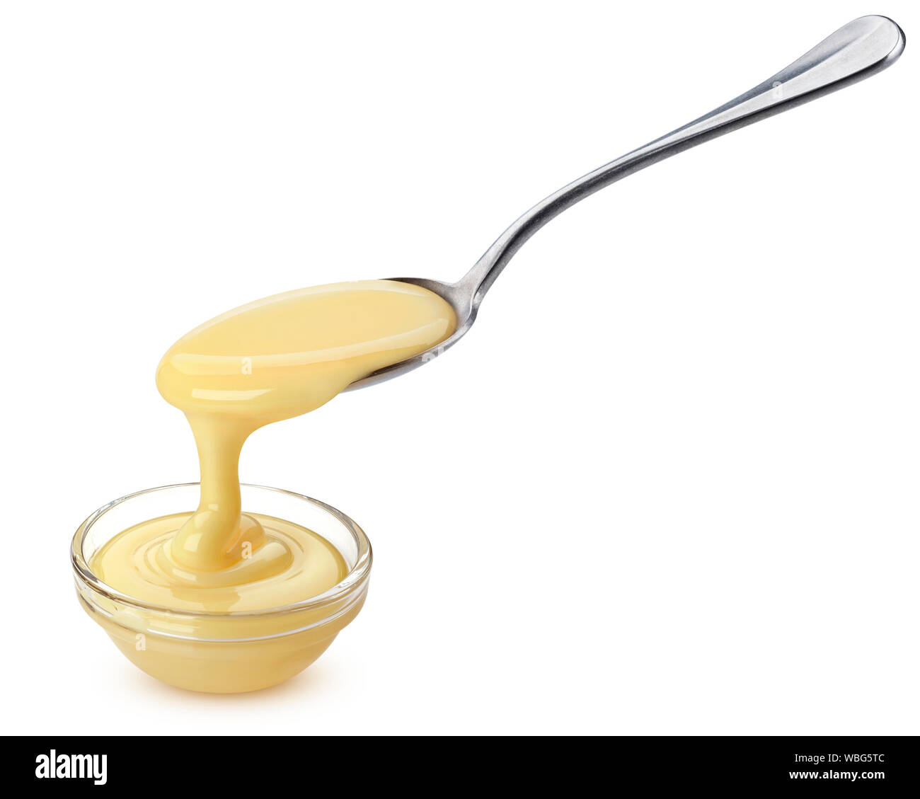 Pouring condensed milk isolated on white background Stock Photo - Alamy