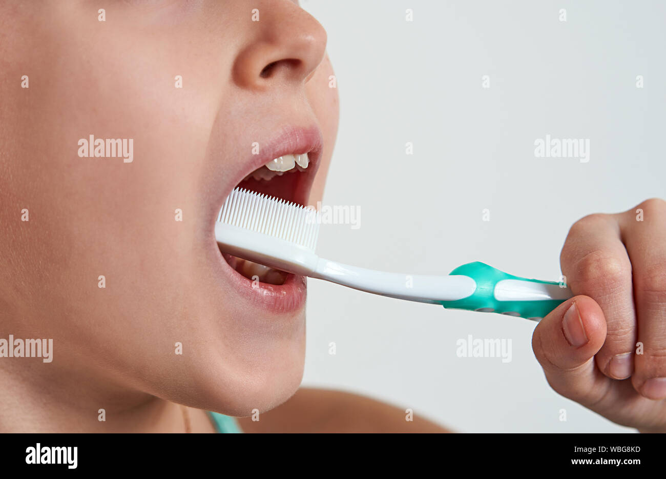 girl brushing her teeth close-up on white background Stock Photo - Alamy