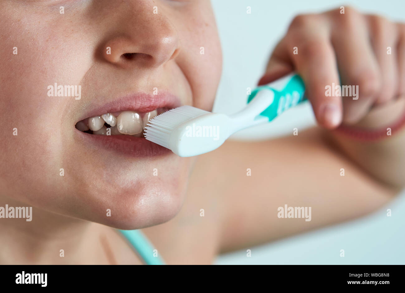 girl brushing her teeth close-up on white background Stock Photo - Alamy