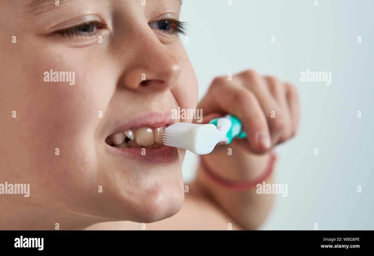 girl brushing her teeth close-up on white background Stock Photo - Alamy