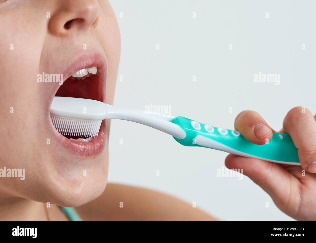 girl brushing her teeth close-up on white background Stock Photo - Alamy