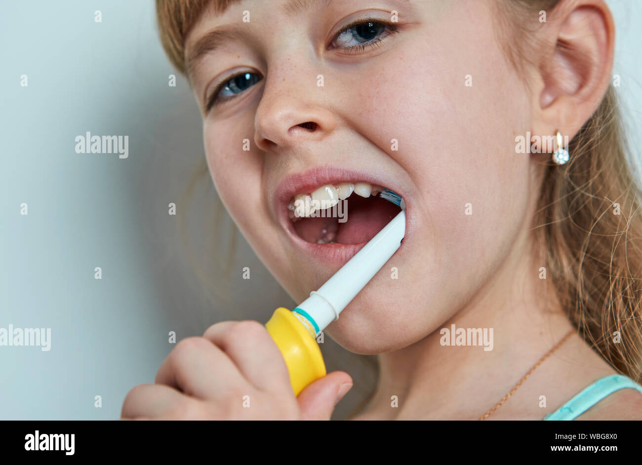 girl brushing her teeth close-up on white background Stock Photo - Alamy