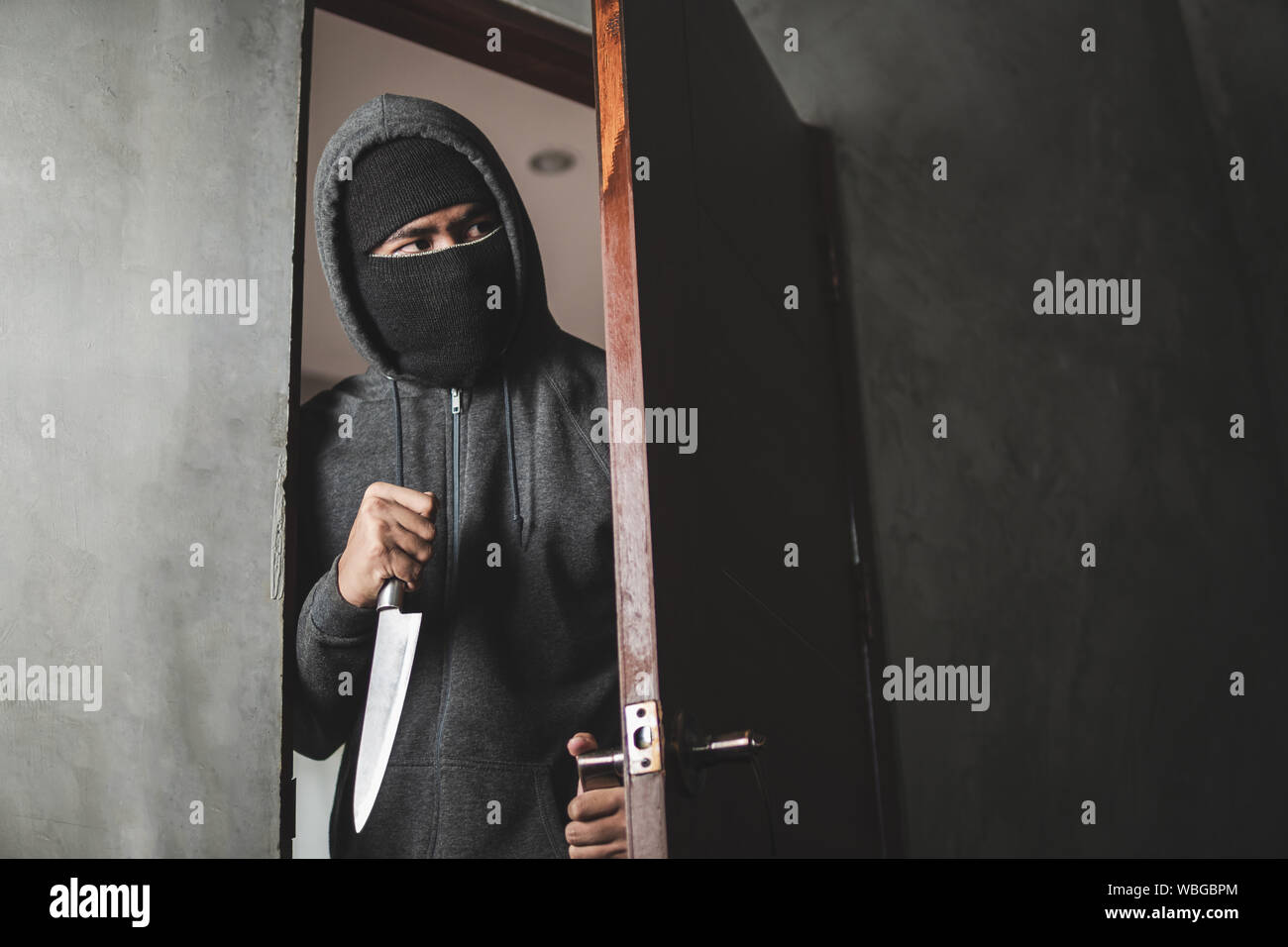 The thief holds a knife to open the house door for robbery Stock Photo ...