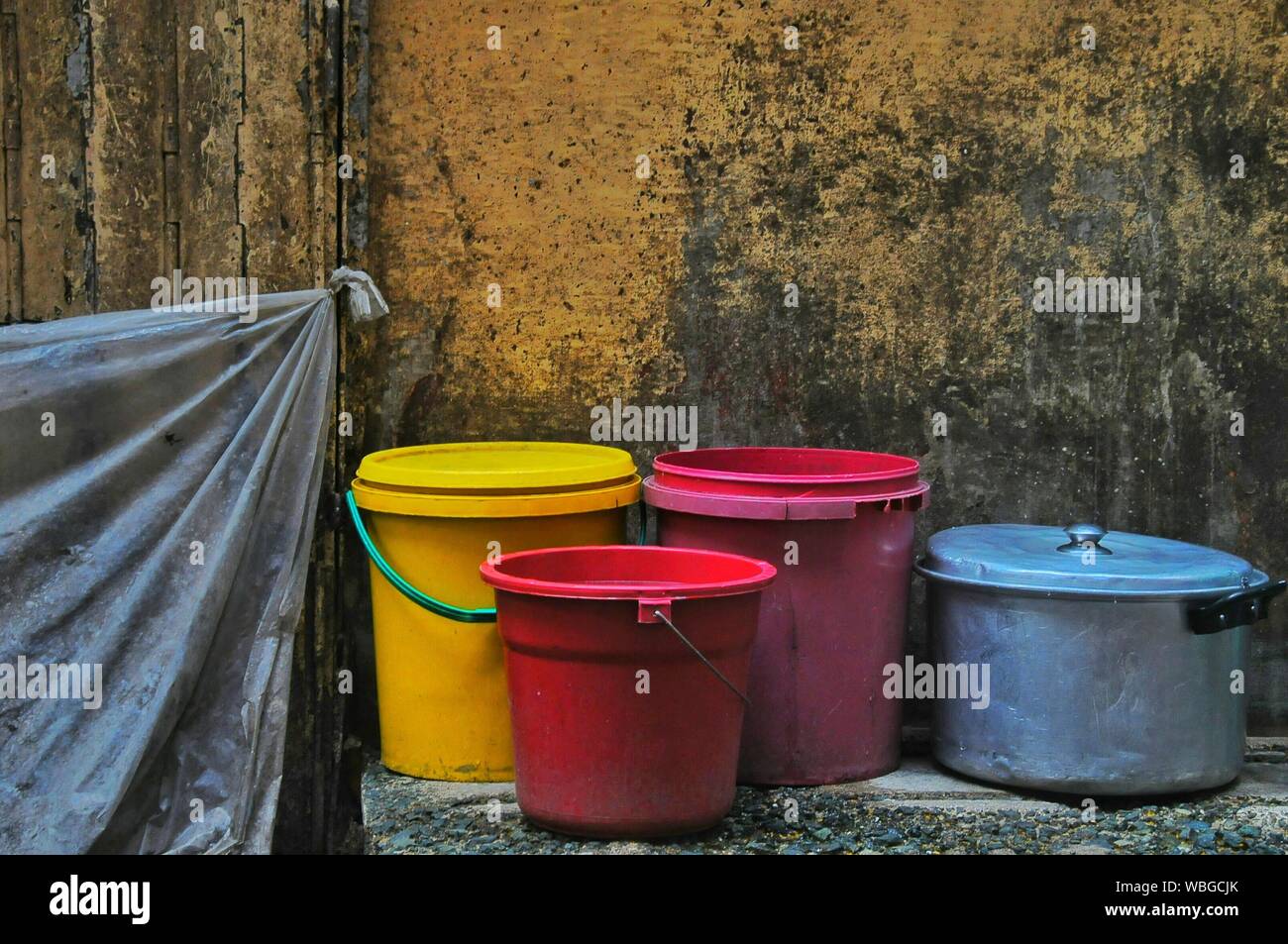 Containers And Buckets On Retaining Wall Stock Photo - Alamy