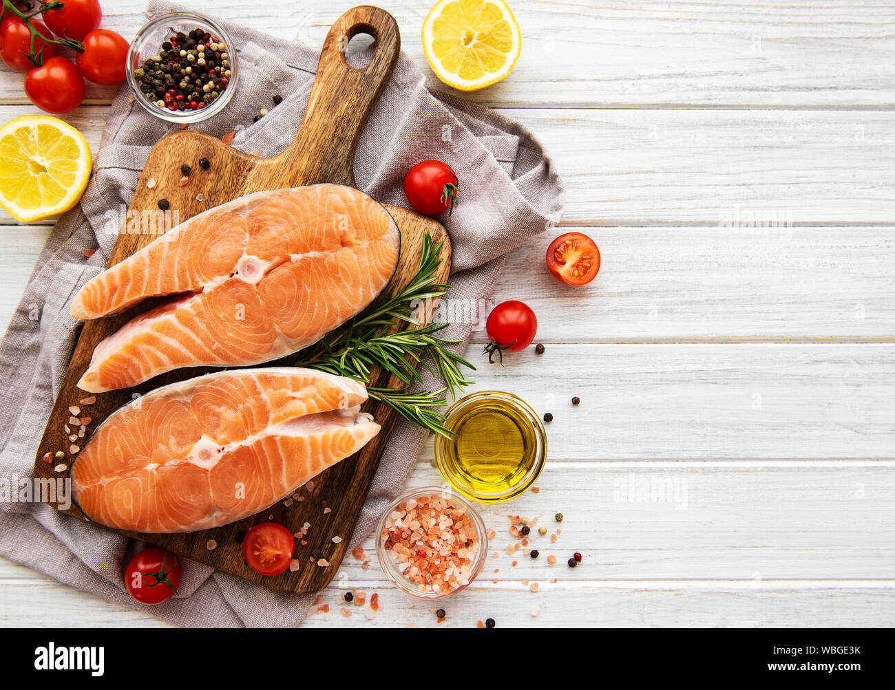 Raw salmon steaks and ingredients on a white wooden table Stock Photo ...