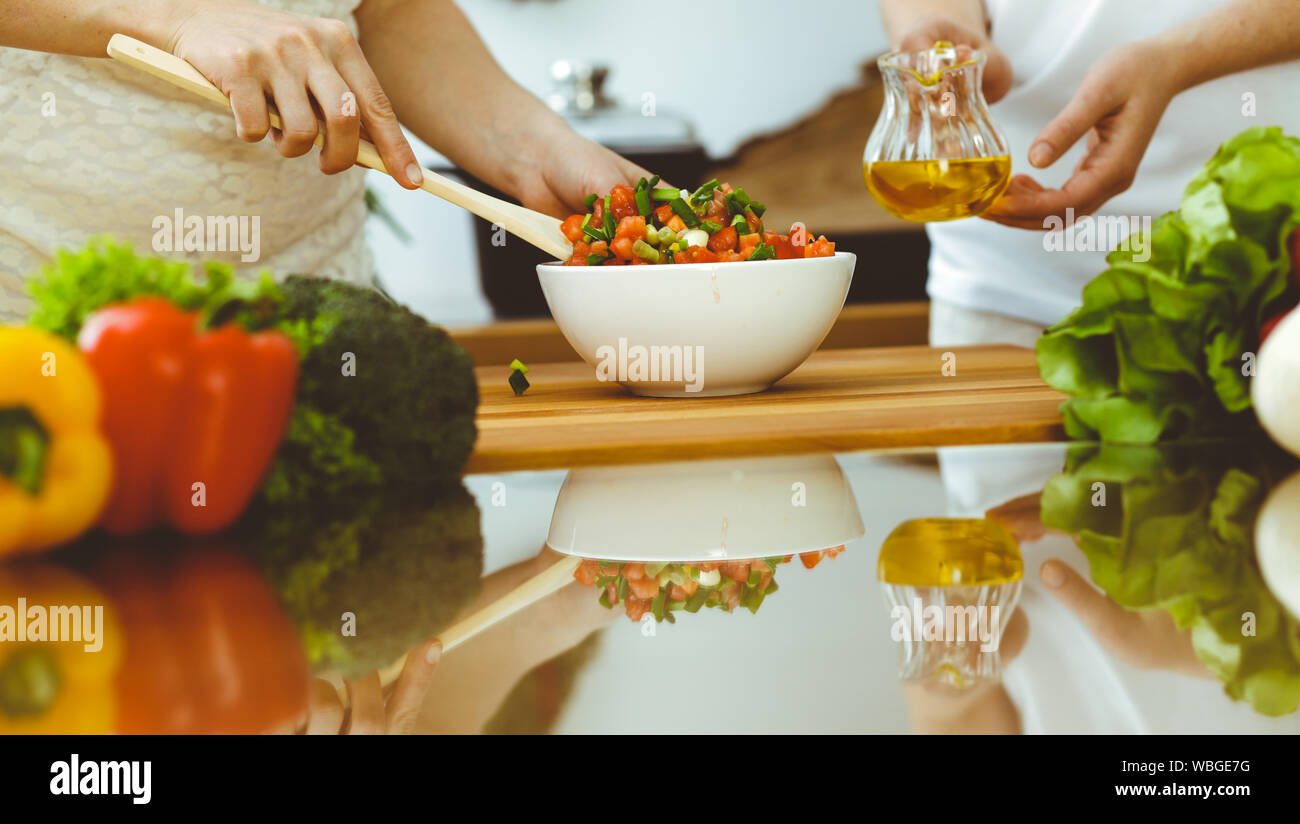 Closeup of human hands cooking in kitchen. Mother and daughter or two ...