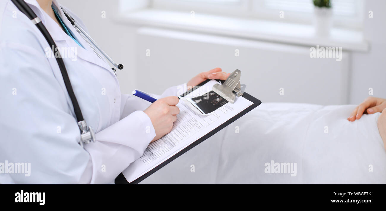 Female doctor holding application form while consulting patient Stock ...