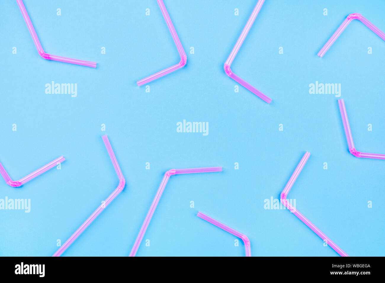 Blue background of pink plastic straws. Flat lay, top view Stock Photo ...