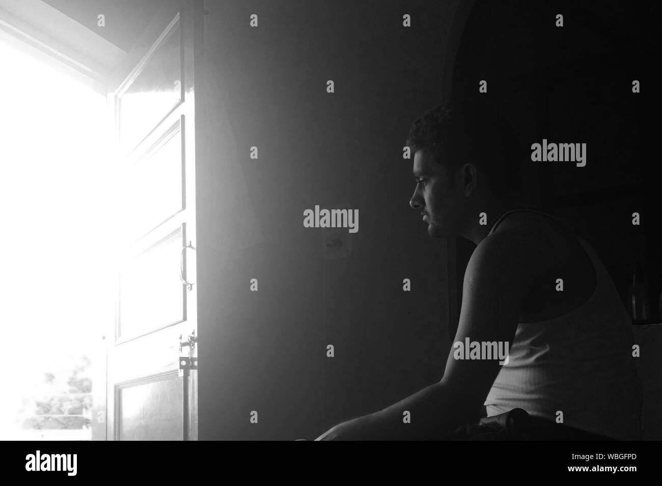 Sad man sitting in dark hi-res stock photography and images - Alamy