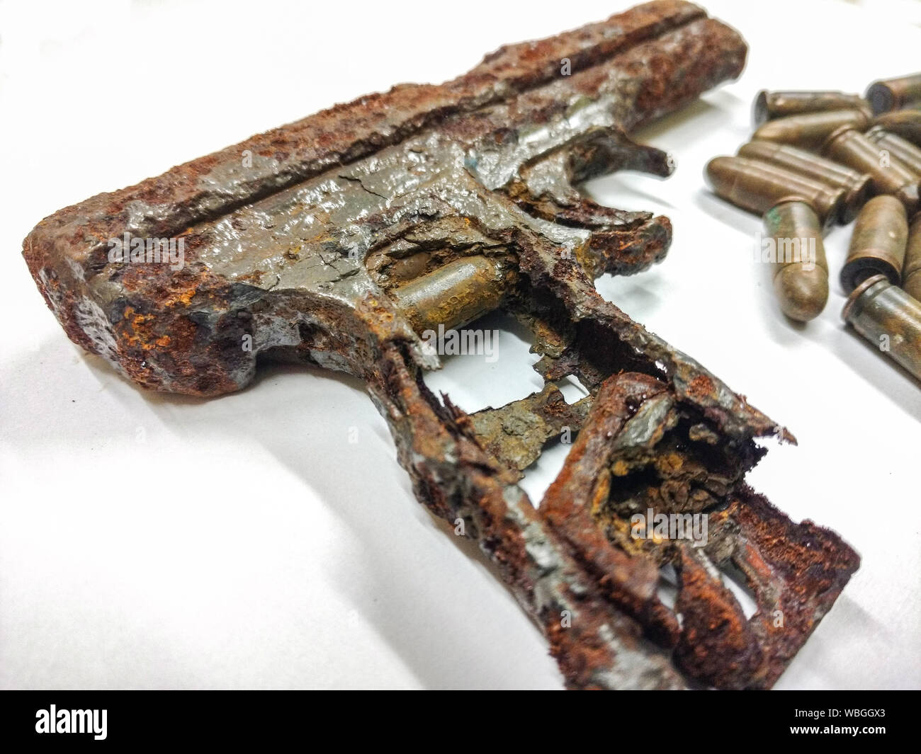 Close-up Of Damaged Rusty Metallic Gun With Bullets On White Background ...