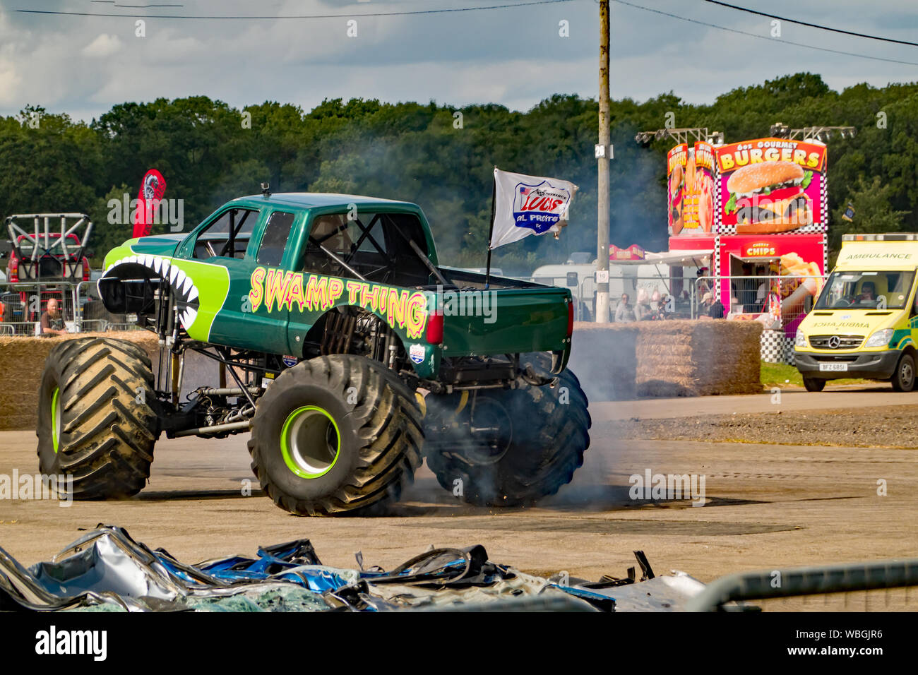 The monster truck Swamp Thing smoking its tires whilst performing a ...