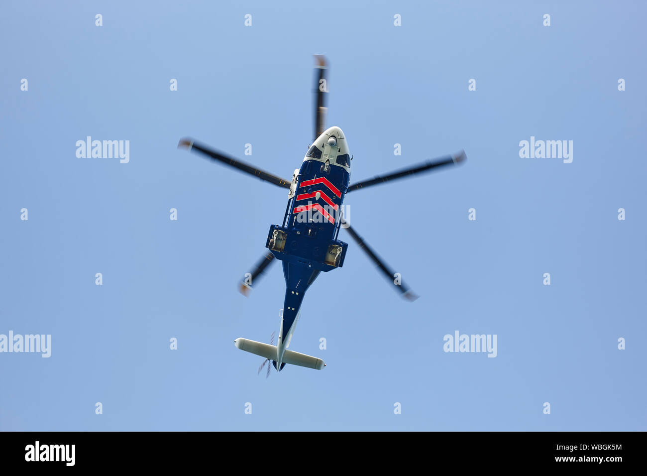 Helicopter flying under a blue sky from below. Air transport Stock ...