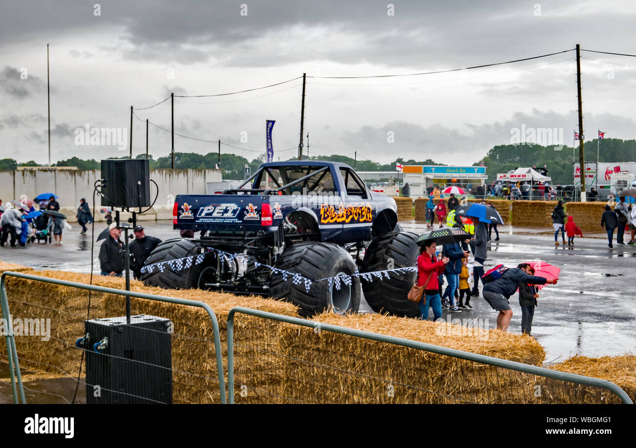 Monster truck fans looking around the monster trucks in the paddock, in ...