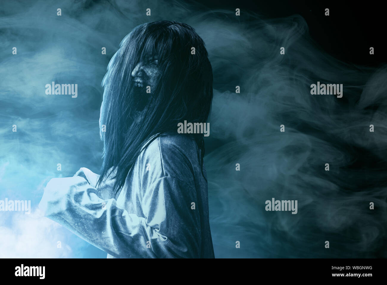 Scary ghost woman with blood and angry face standing amid the dark fog ...