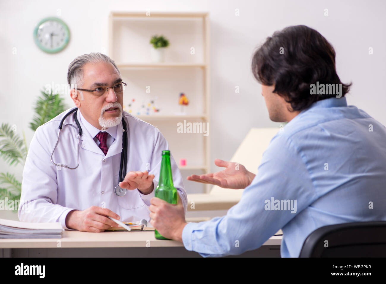 The young male alcoholic visiting old doctor Stock Photo - Alamy
