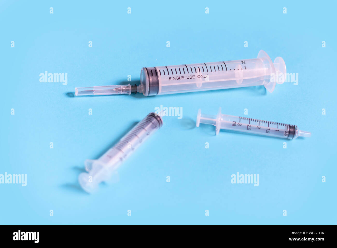 Injection needle on blue background. Multiple syringes. Syringes that ...