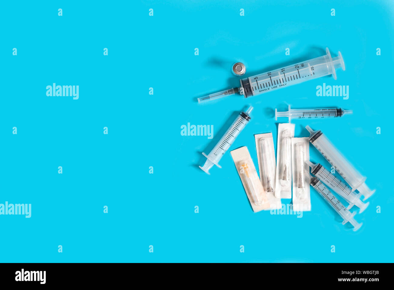 Vials with medication and injection needle on blue background. Top view ...
