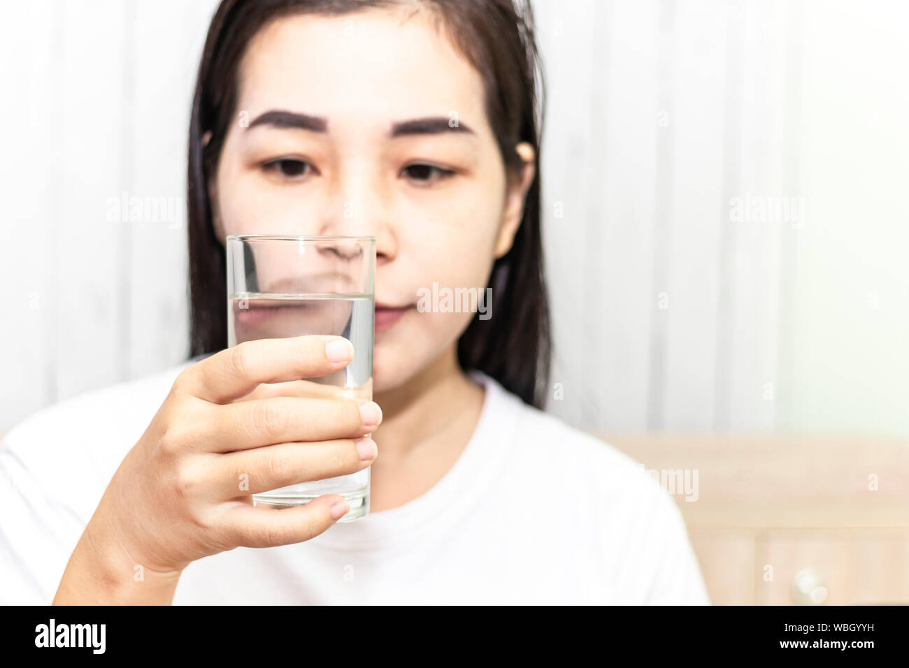 Cute asian young woman drink water from glass. Beautiful young girl hand holding drinking water ...