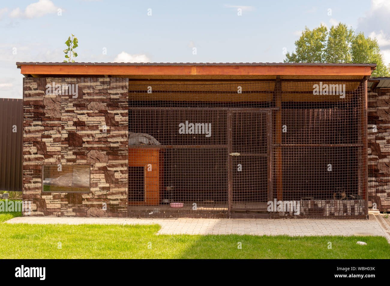 Stylish and large aviary for a German shepherd in the yard. German ...