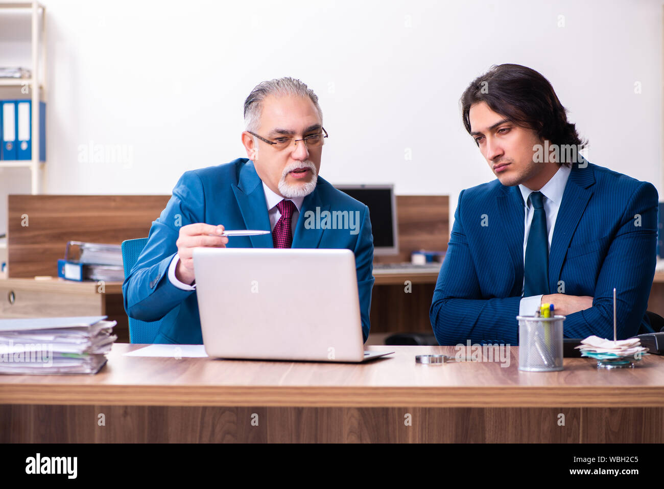 The young and old employees working together in the office Stock Photo ...