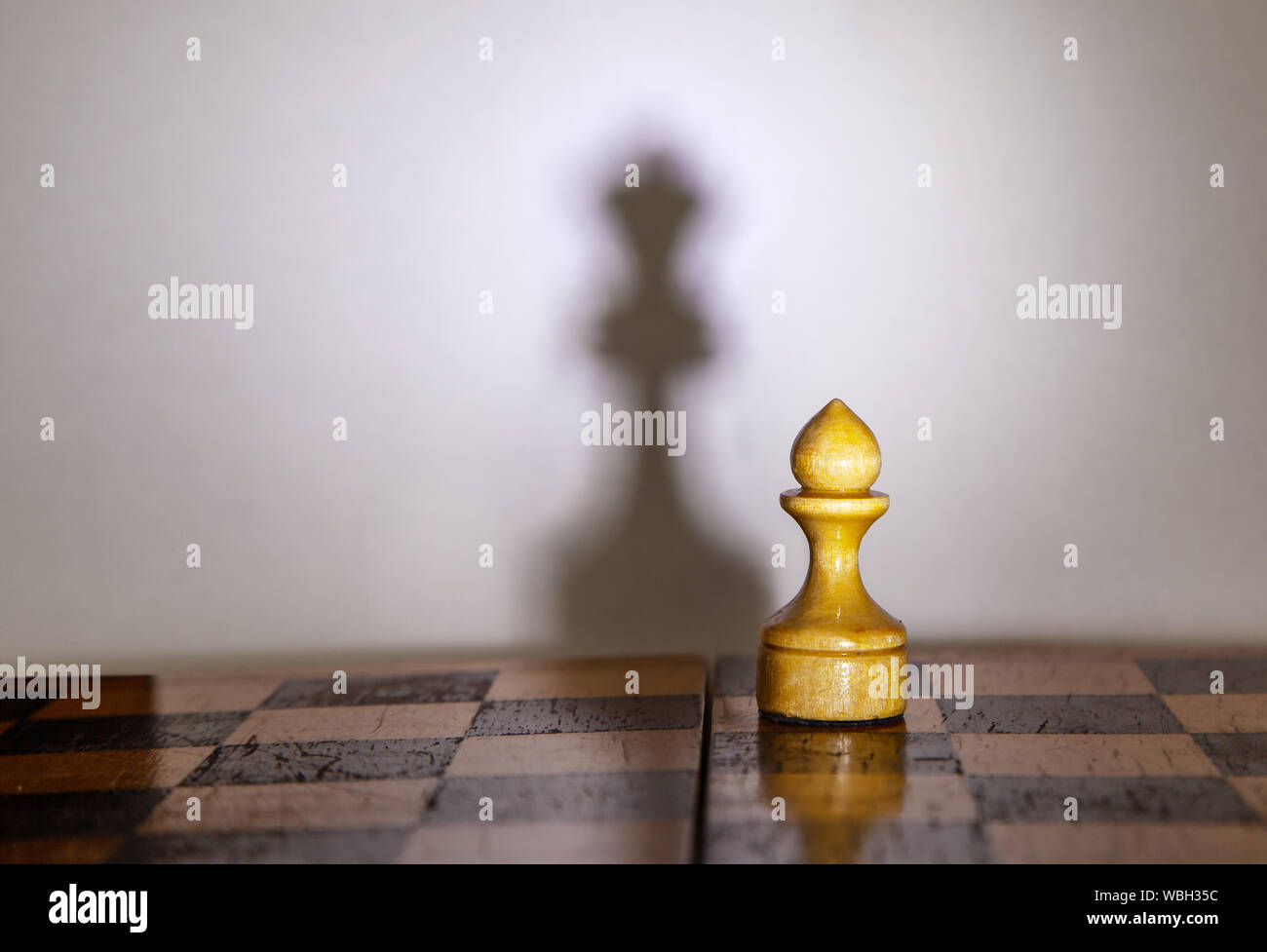 chess pawn with the shadow of a queen on chessboard closeup. concept i ...