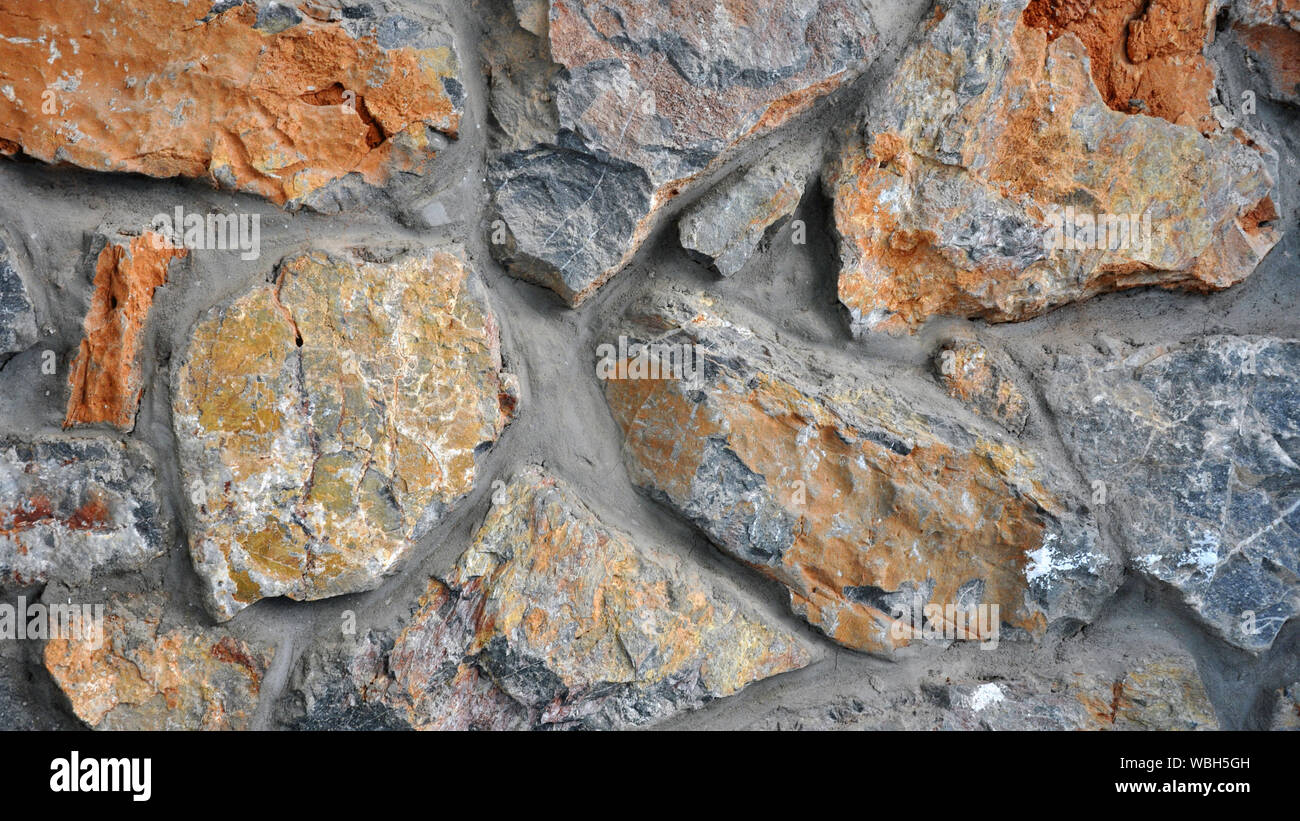 Wall made of natural stone with a red tint. Texture, background Stock ...
