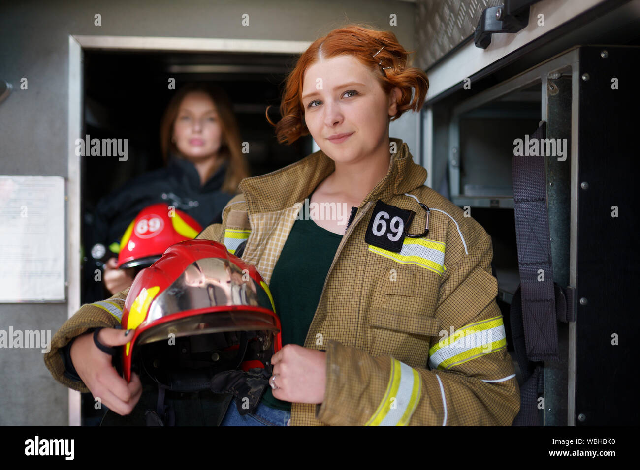 Picture of two female firefighters in fire truck at station Stock Photo ...