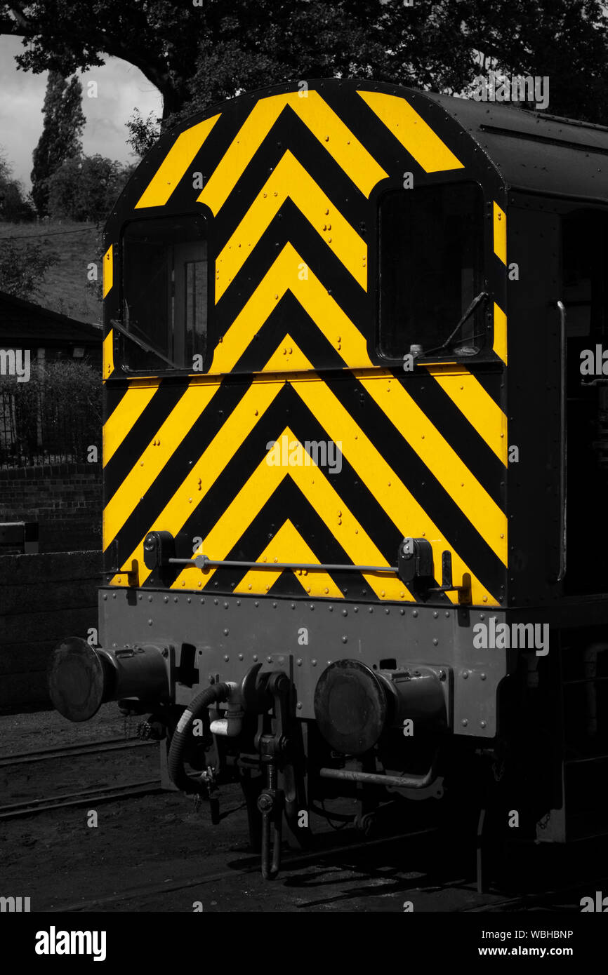 Diesel freight train locomotive with yellow and black warning hazard ...
