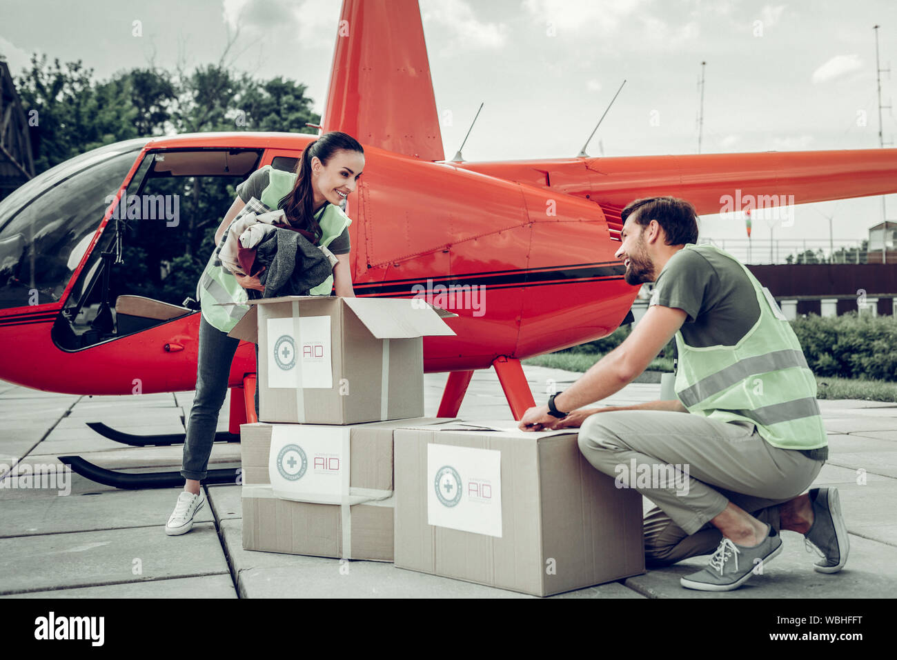 Volunteers packing clothes into boxes for sending them with helicopter ...
