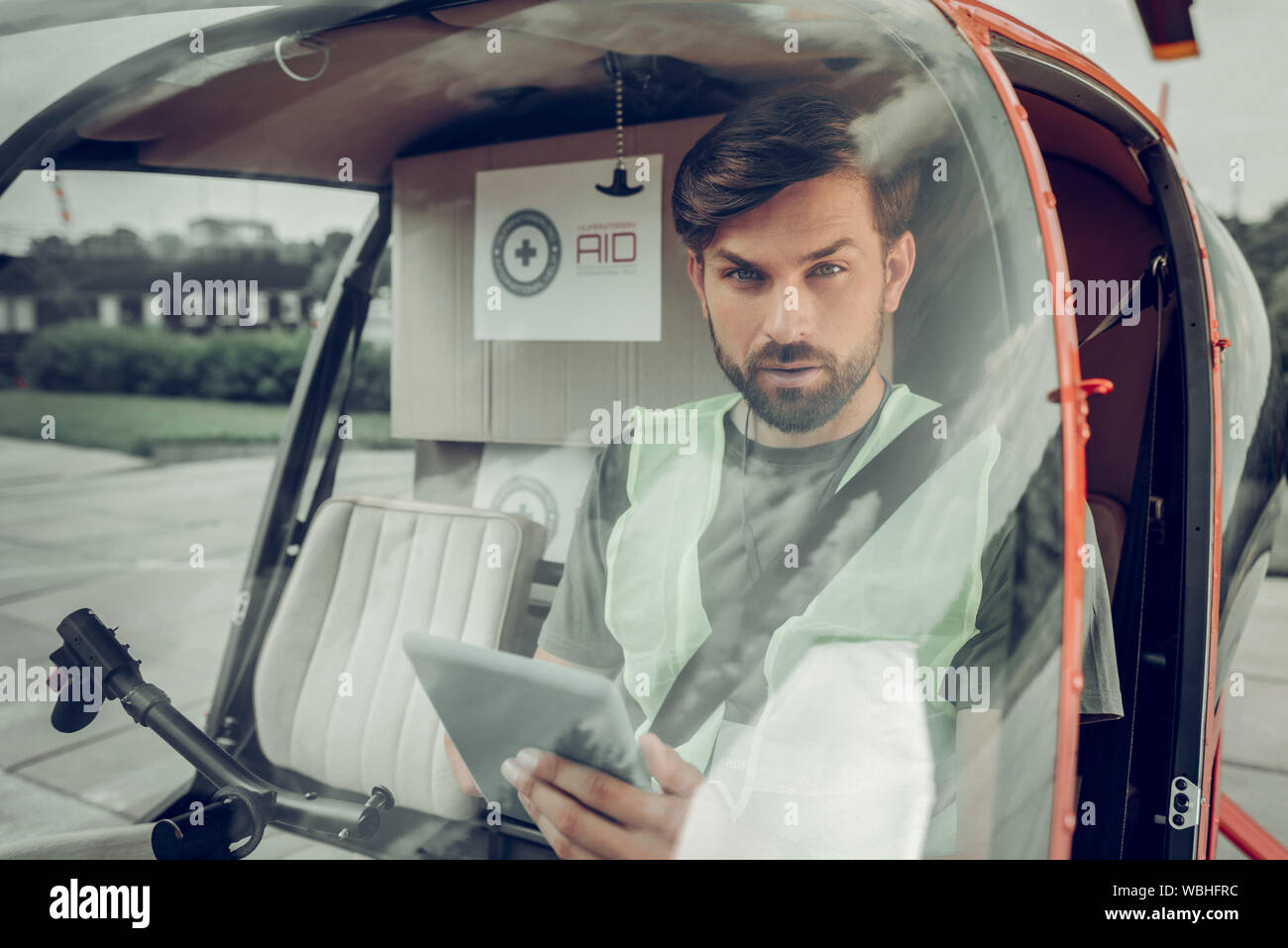 Pilot texting colleague sitting in helicopter before flying Stock Photo ...