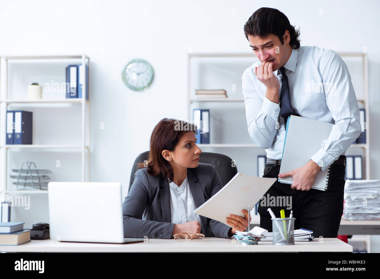 The old female boss and young male employee in the office Stock Photo ...