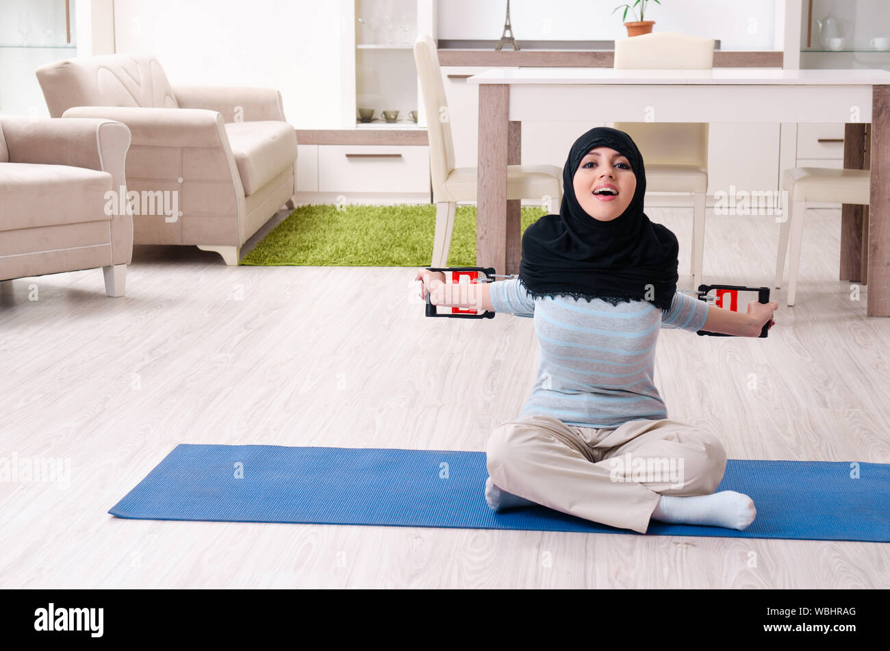 The young woman in hijab doing exercises at home Stock Photo - Alamy