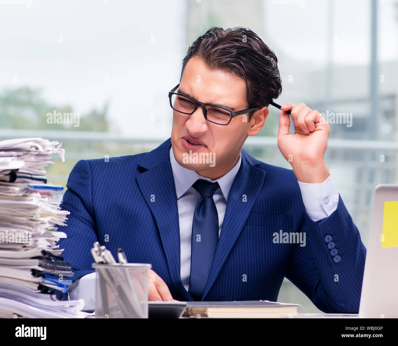 The workaholic businessman overworked with too much work in office ...