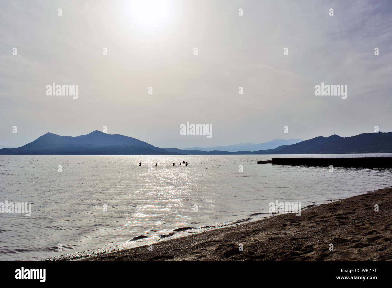 A group of swimmers in Greece bathe in the sea before sunset Stock ...
