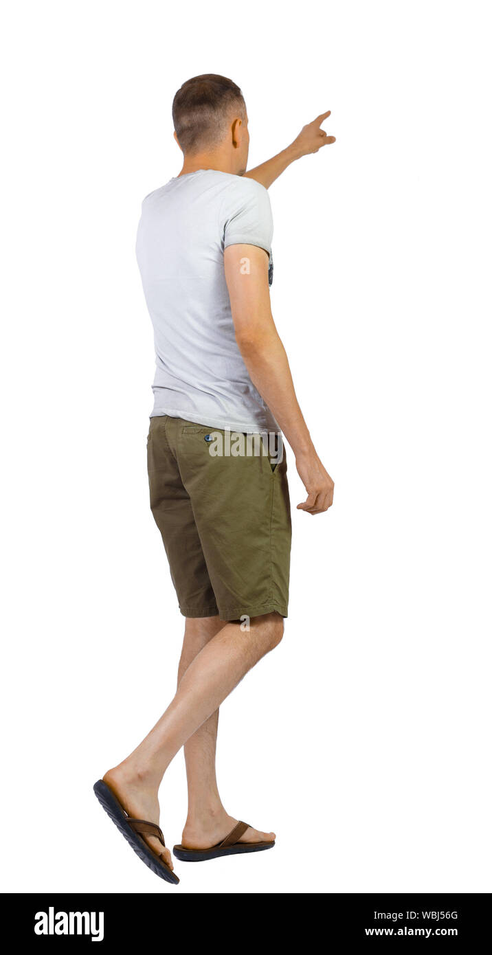 Back view of going pointing man in shorts. walking young guy . Rear ...