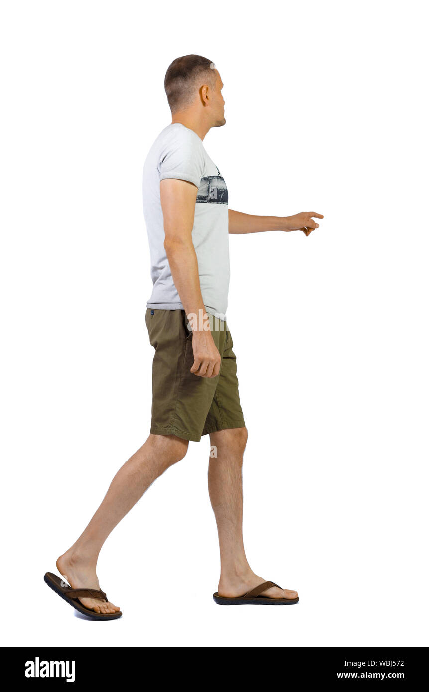 Back view of going pointing man in shorts. walking young guy . Rear ...