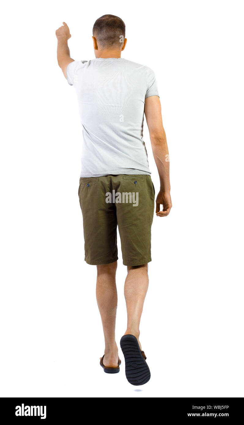 Back view of going pointing man in shorts. walking young guy . Rear ...
